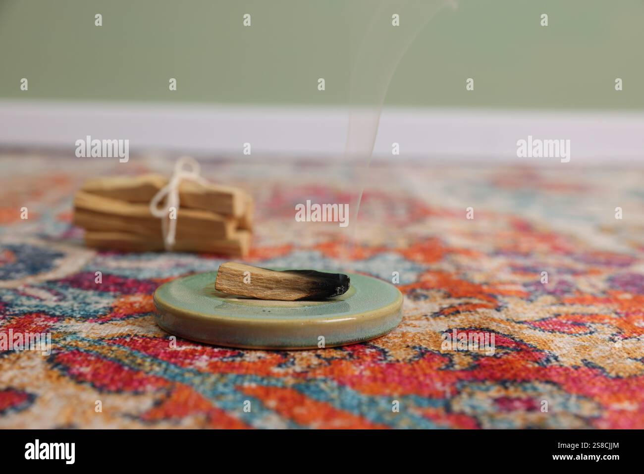 Smoldering palo santo stick on rug indoors Stock Photo - Alamy