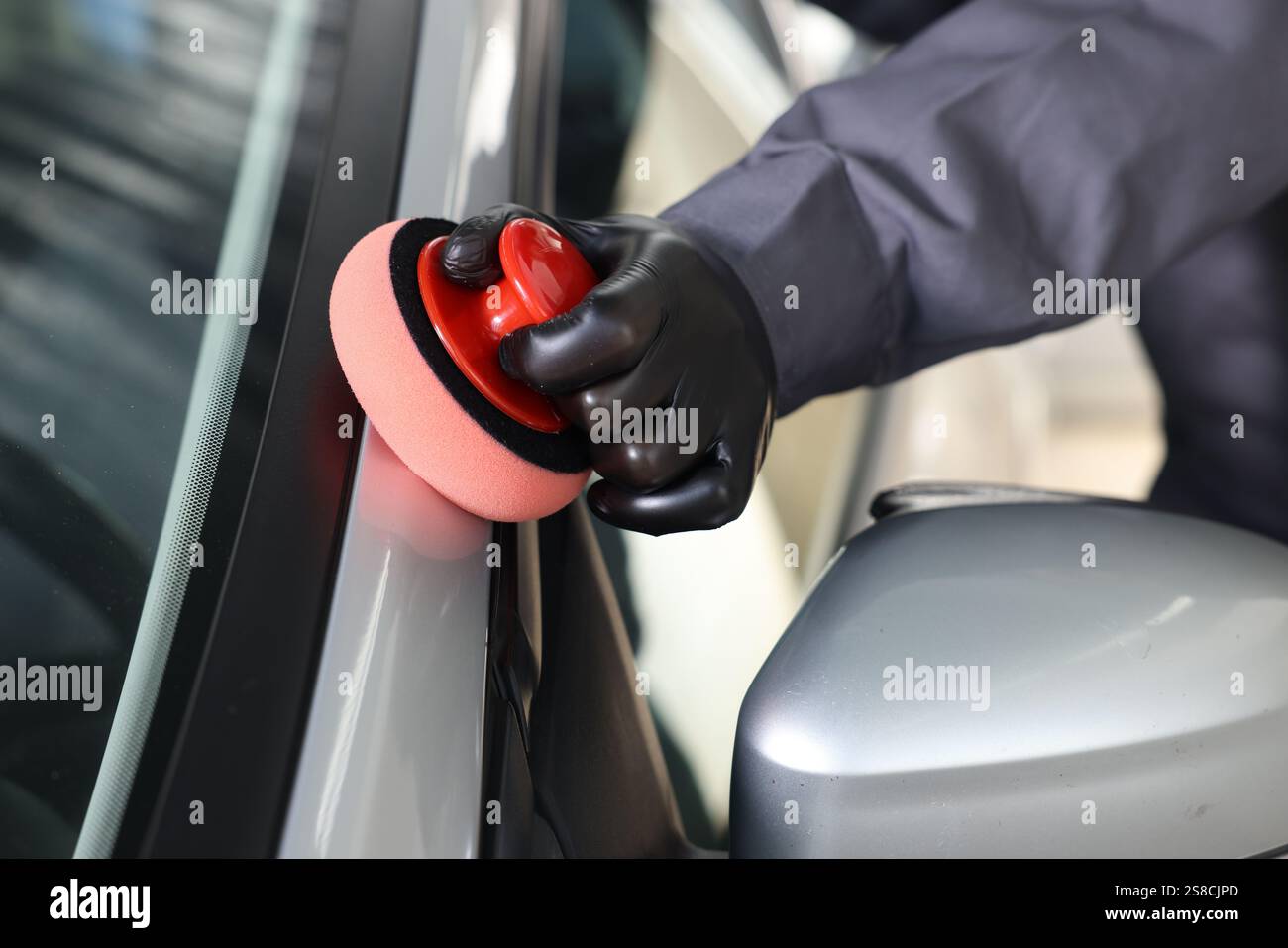 Man polishing car with sponge indoors, closeup Stock Photo - Alamy