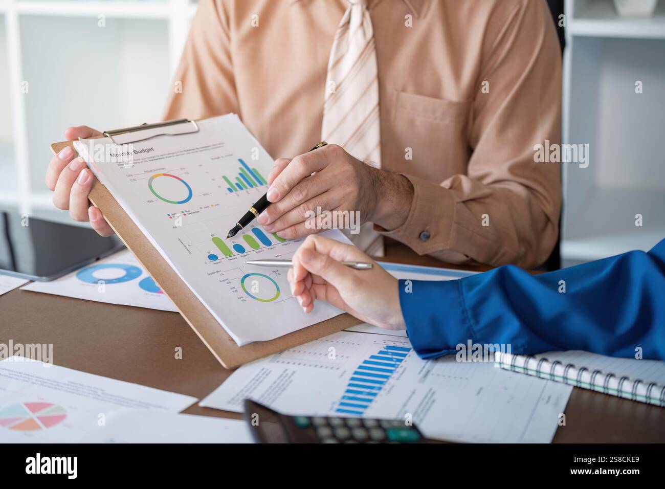 Accountants reviewing monthly budget metrics and performance charts in ...