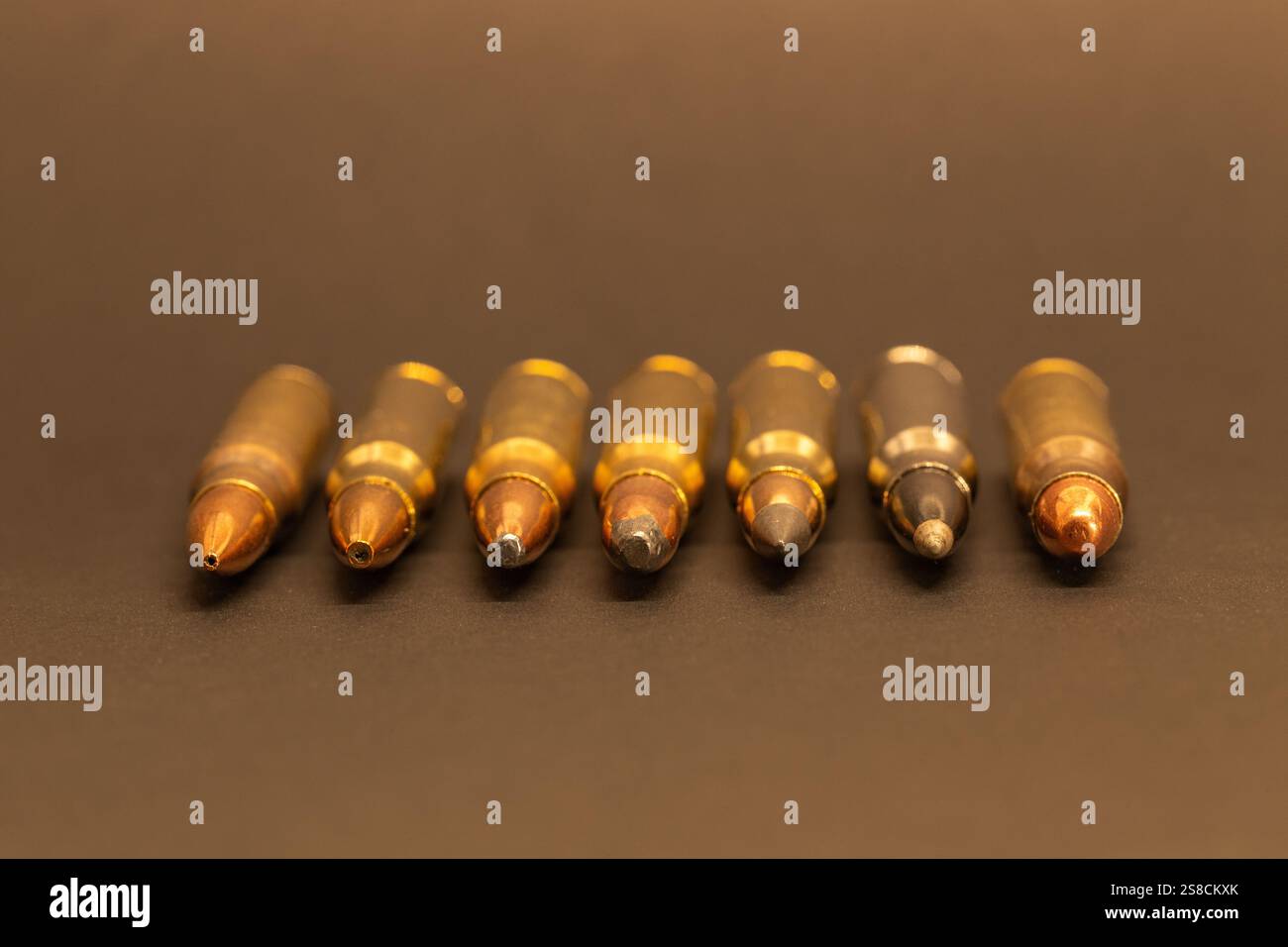 Seven rifle cartridges displayed on a dark surface, highlighting the ...