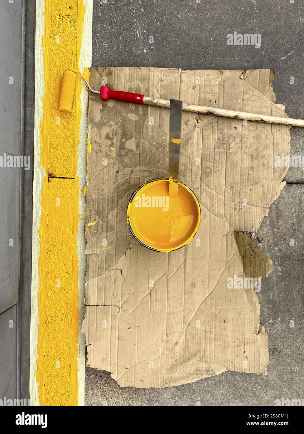 Top view of a line paint roller and a yellow paint can Stock Photo - Alamy