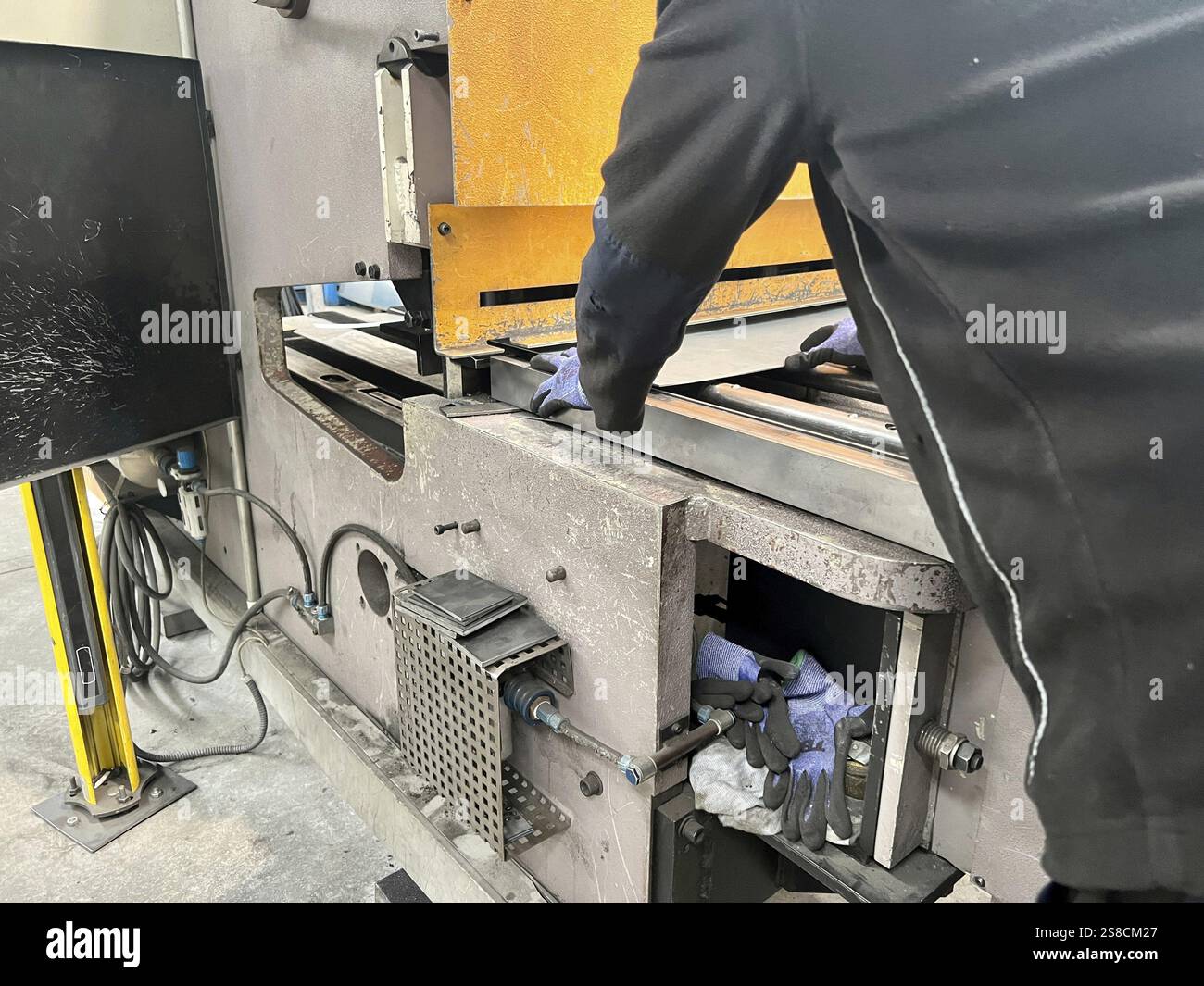 Worker cutting sheet metal on a sheet metal cutting guillotine Stock ...
