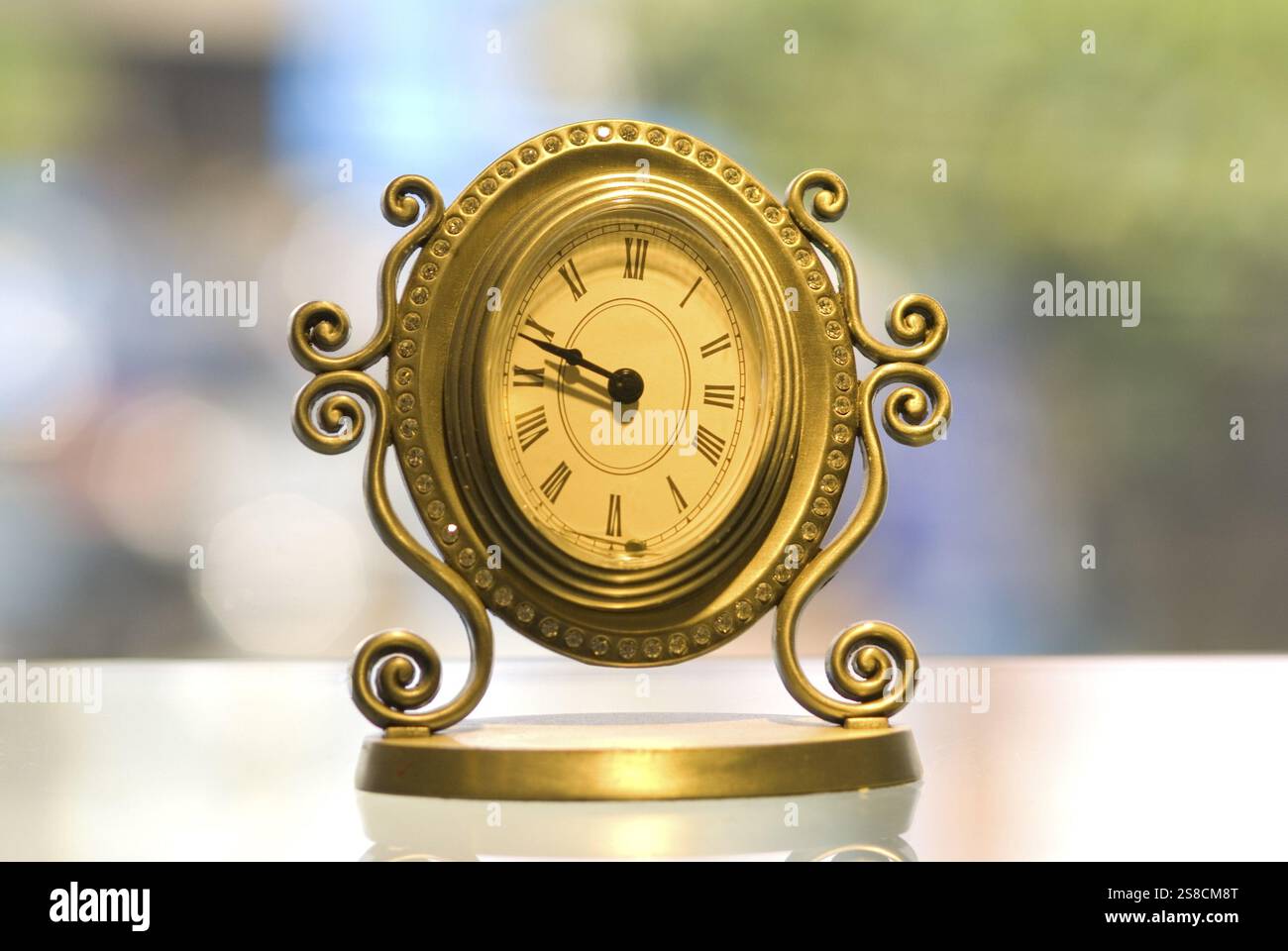 An ornate vintage gold clock with intricate details reflecting on a ...