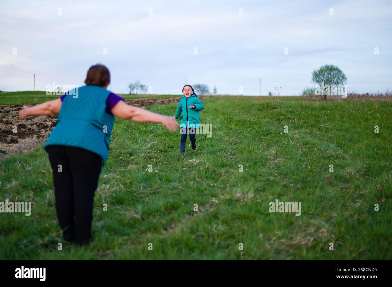 A heartwarming scene of a grandmother welcoming her granddaughter with ...