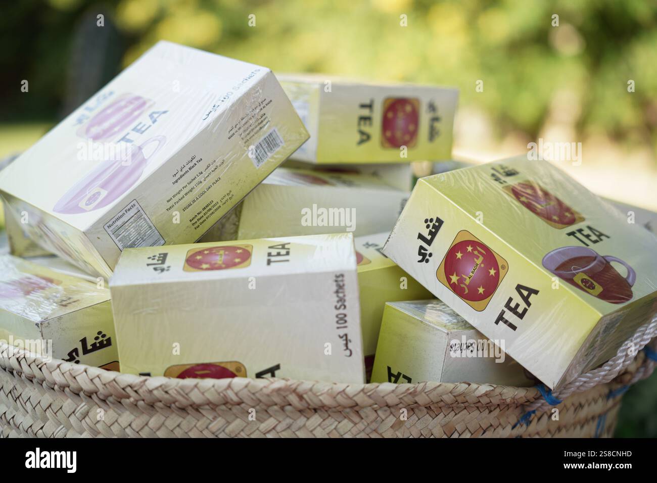 A close-up of yellow tea boxes stacked in a woven basket, featuring ...