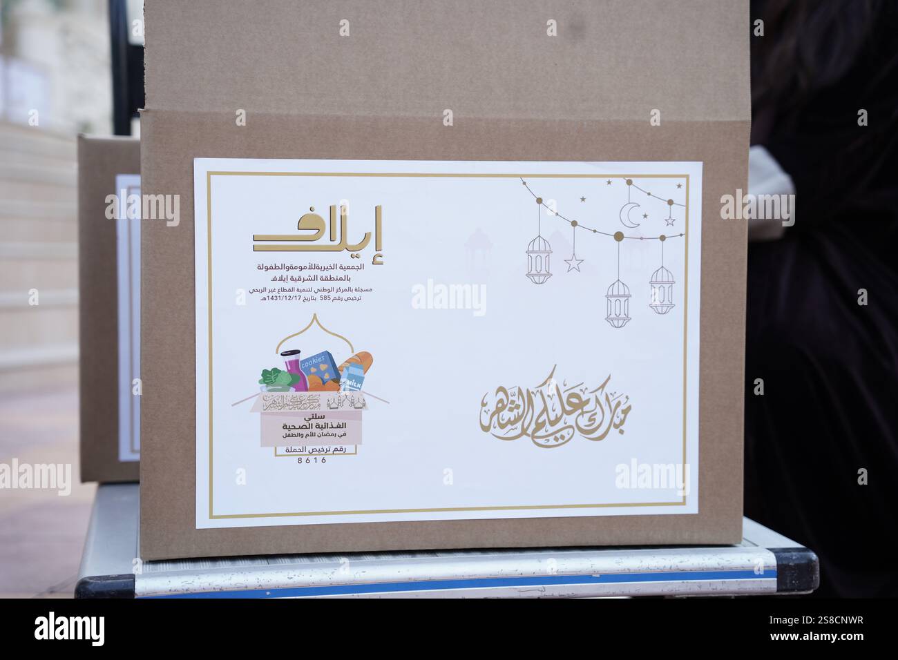 A close-up of a Ramadan charity food donation box with Arabic text and ...