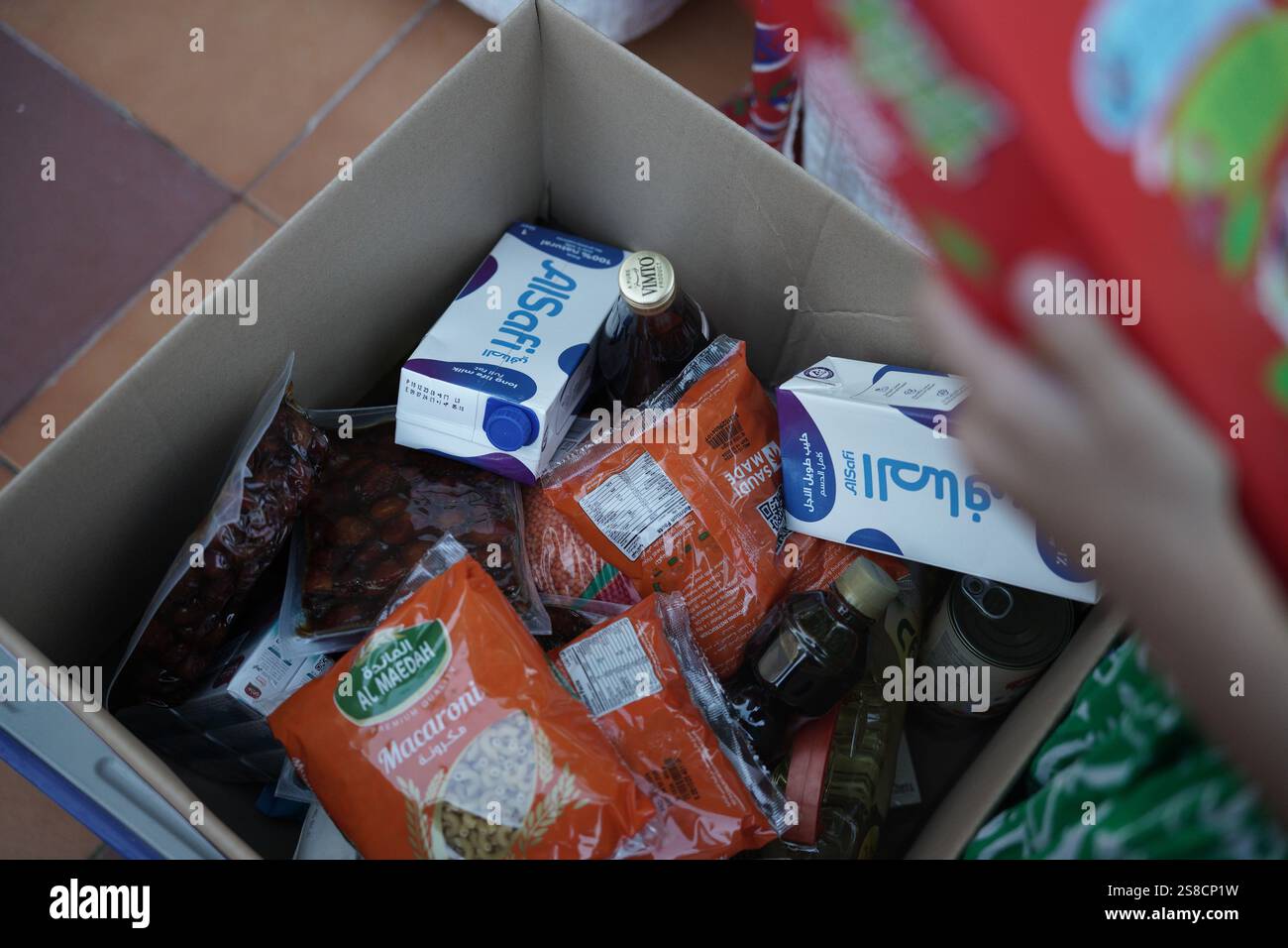 A food donation box containing essential items such as milk cartons ...