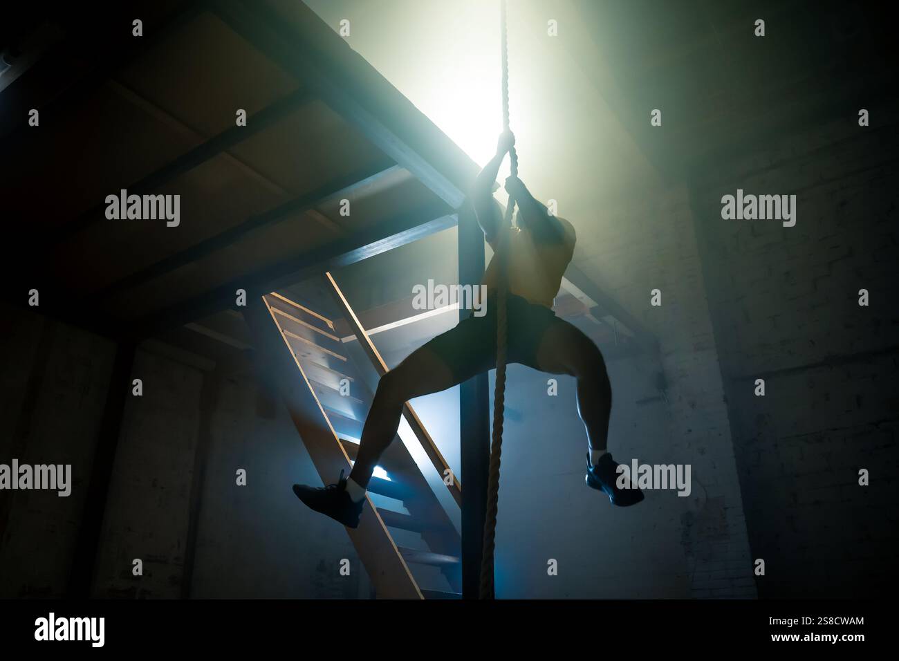 An athlete is seen dramatically climbing a gym pole, showcasing ...
