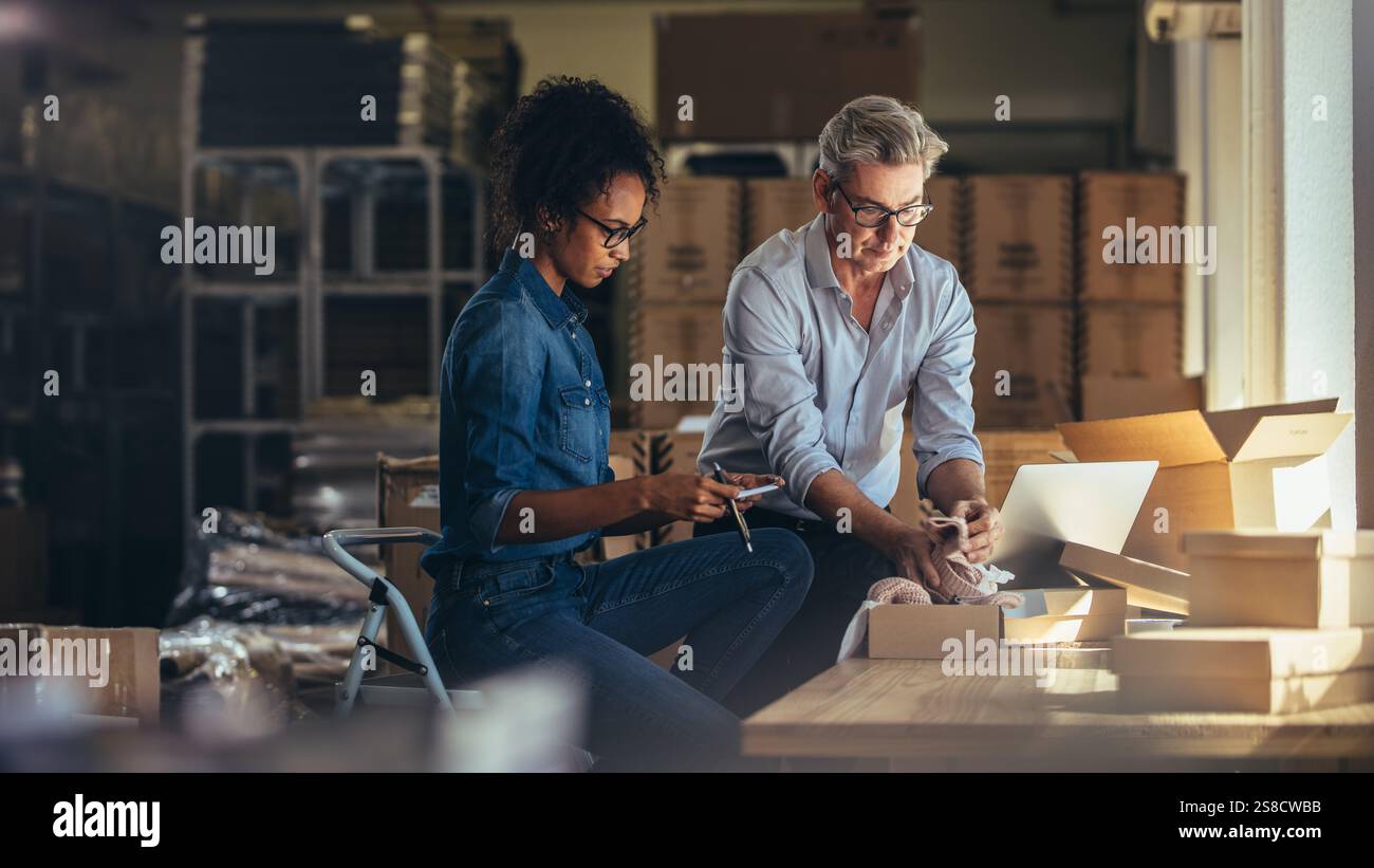 Man packing the product in the box with woman preparing the invoice ...
