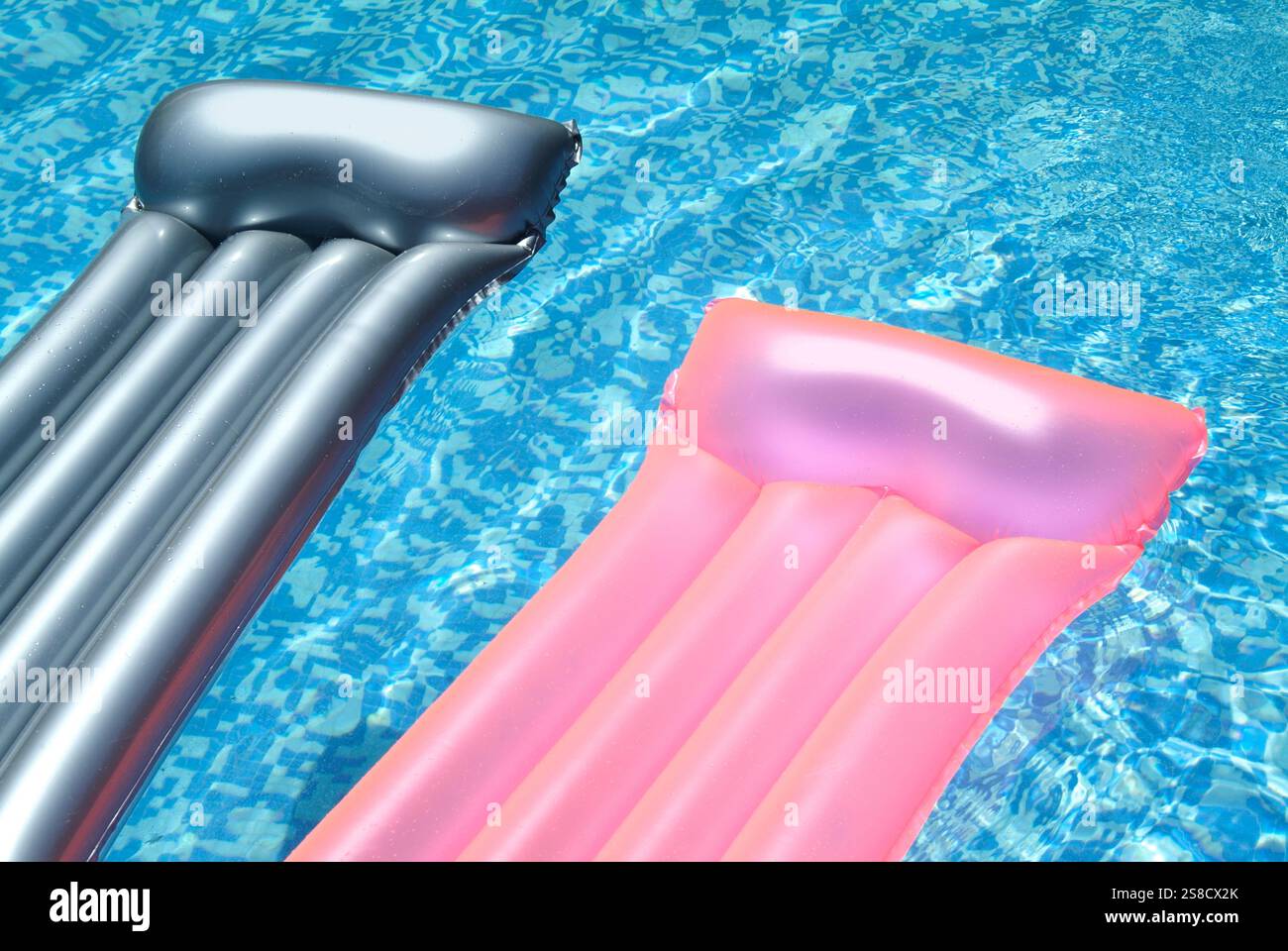 Colour air mattresses on swimming pool Stock Photo - Alamy