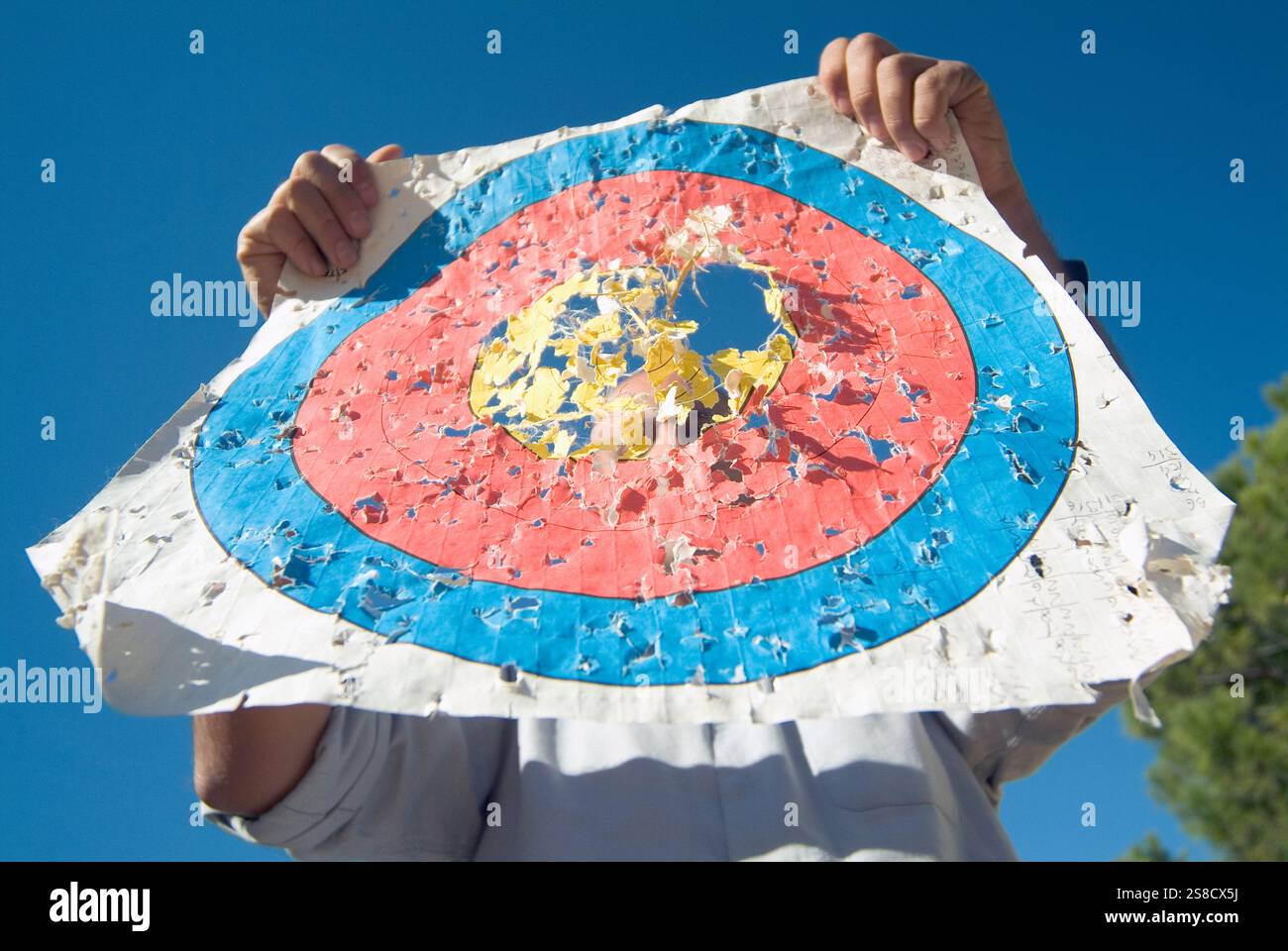 Hands showing a perforated archery target Stock Photo - Alamy