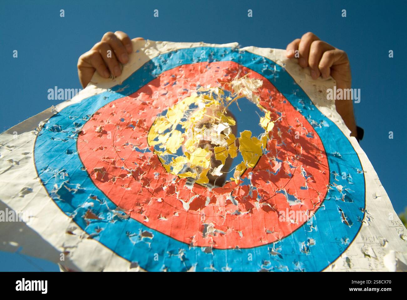 Hands showing a perforated archery target Stock Photo - Alamy