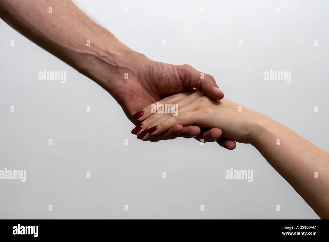 Man is giving a helping hand to a woman with red nail polish on a white ...