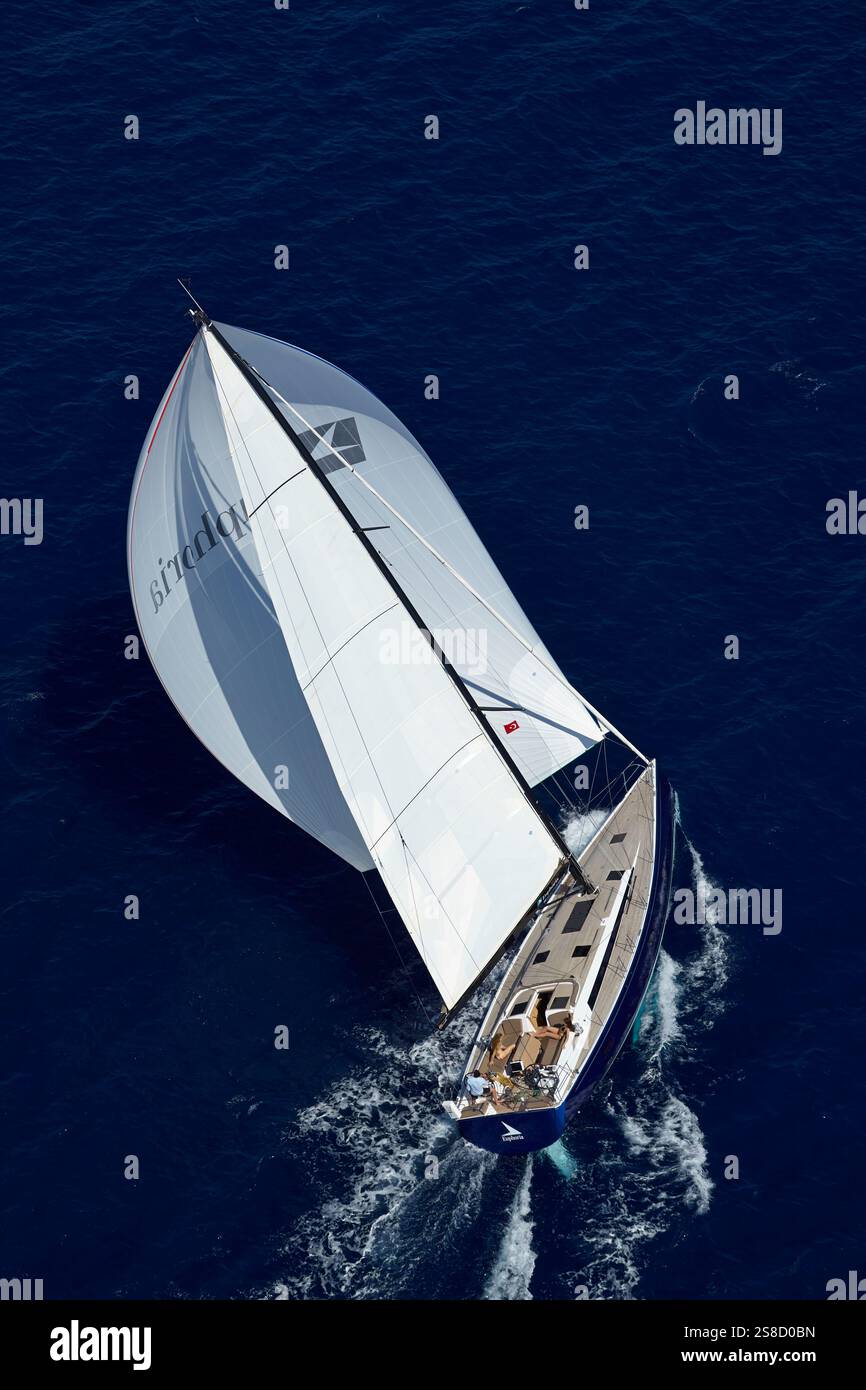 Aerial View of a Sailing Yacht with Spinnaker Navigating Open Seas on a ...