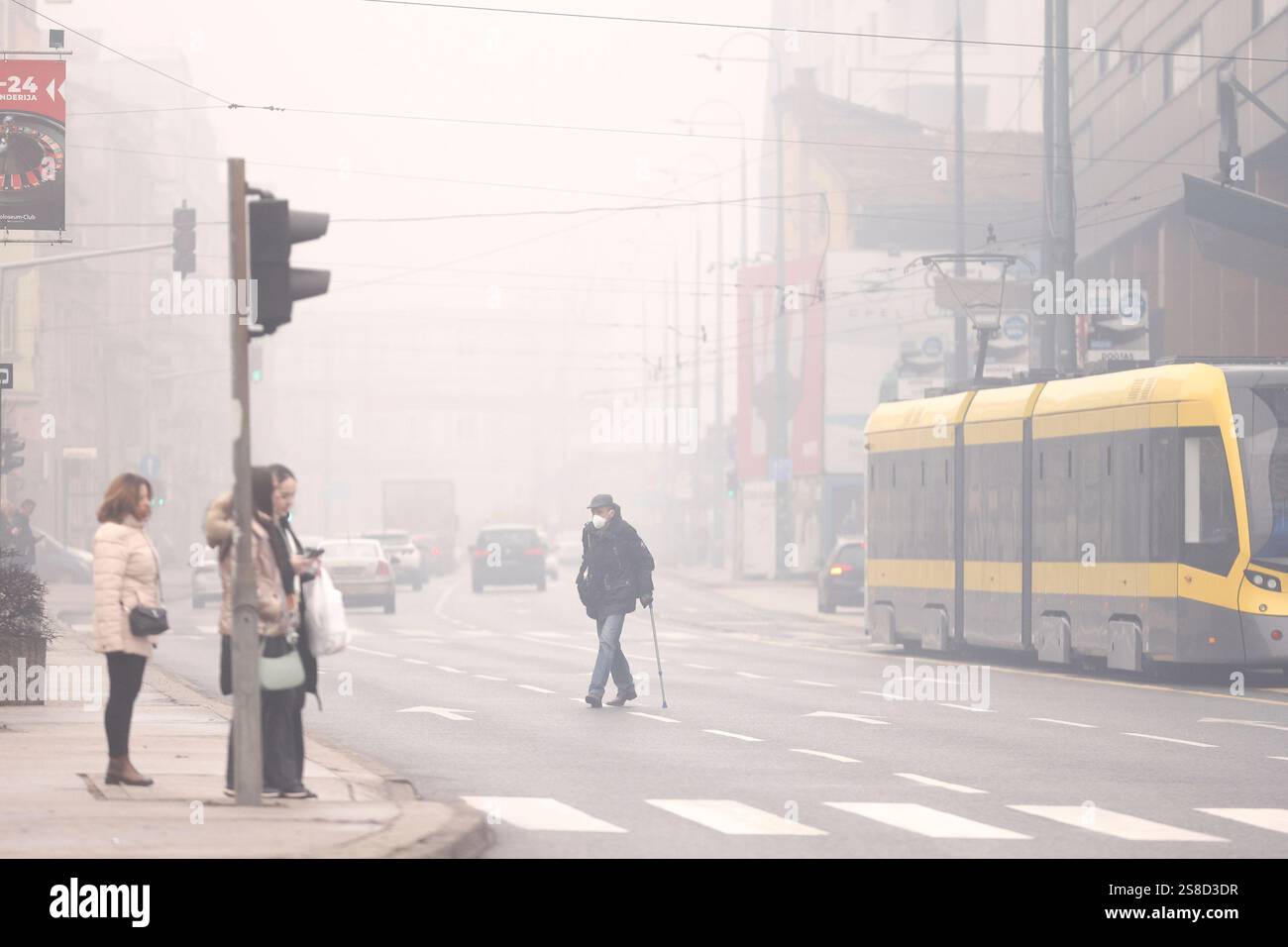Man wearing a face mask to protect from air pollution crosses the ...