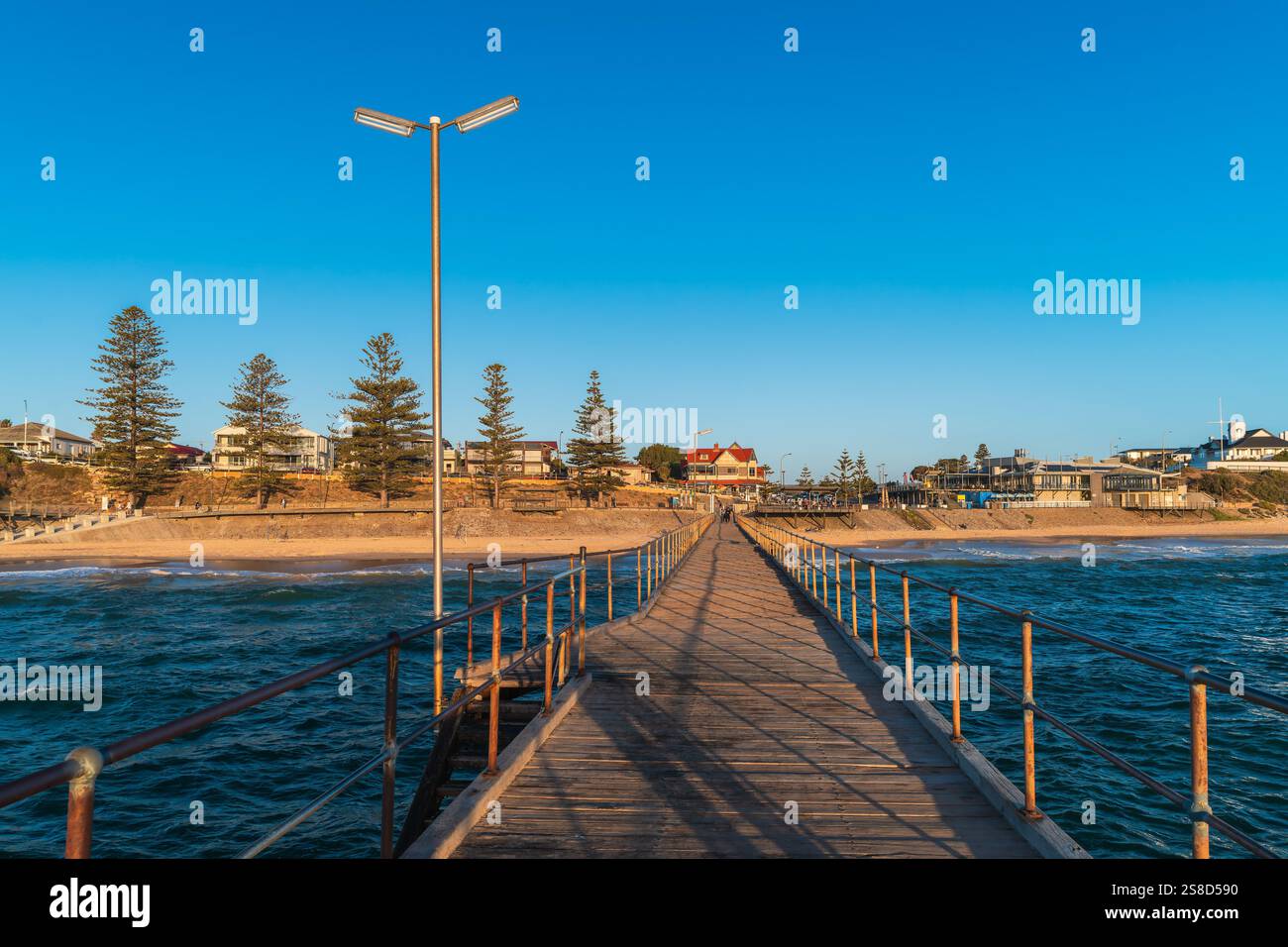 Port Noarlunga jetty with people viewed towards the beach at sunset ...