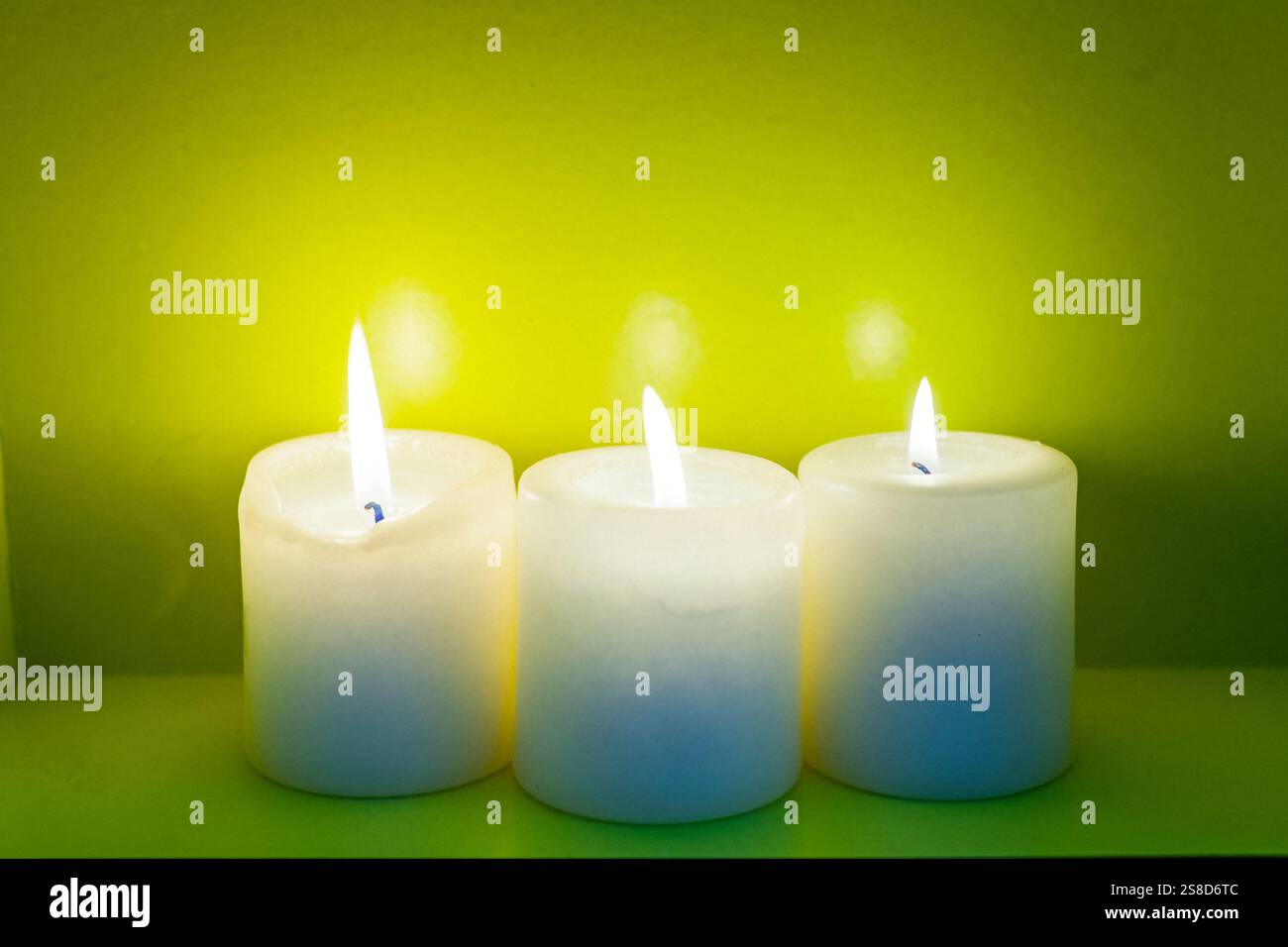 Colorful scented candles on a dark green background Stock Photo - Alamy