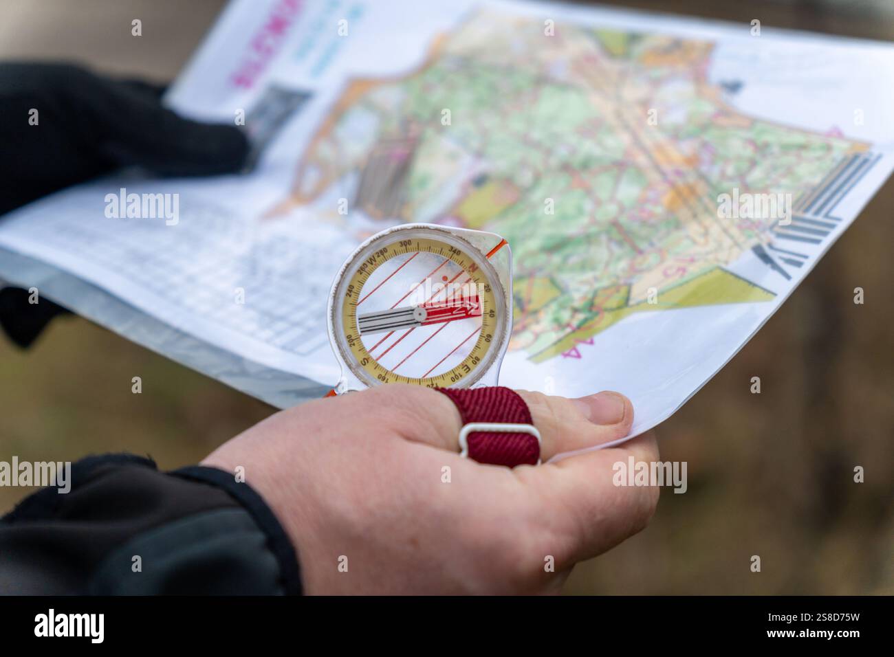 Athlet holding a map and the compass during orienteering competitions ...