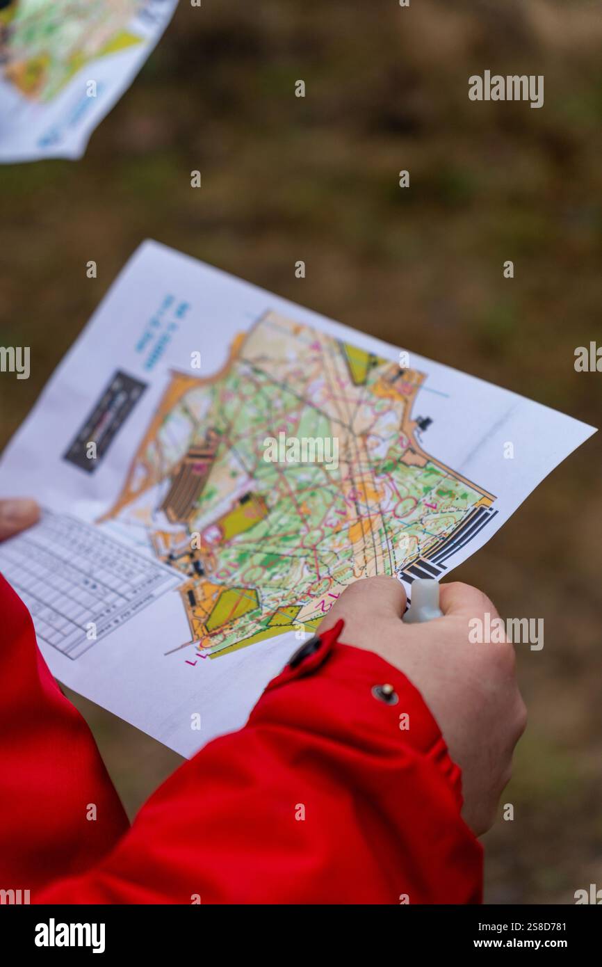 Athlete holding a map during orienteering competitions. Athlete uses ...