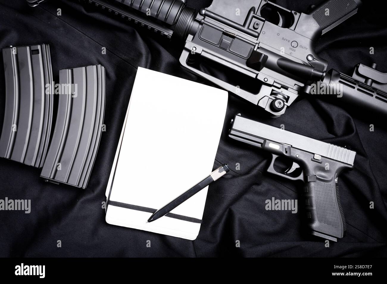 Rifle, gun, knife with sheath, compass and notebook with pen on on ...