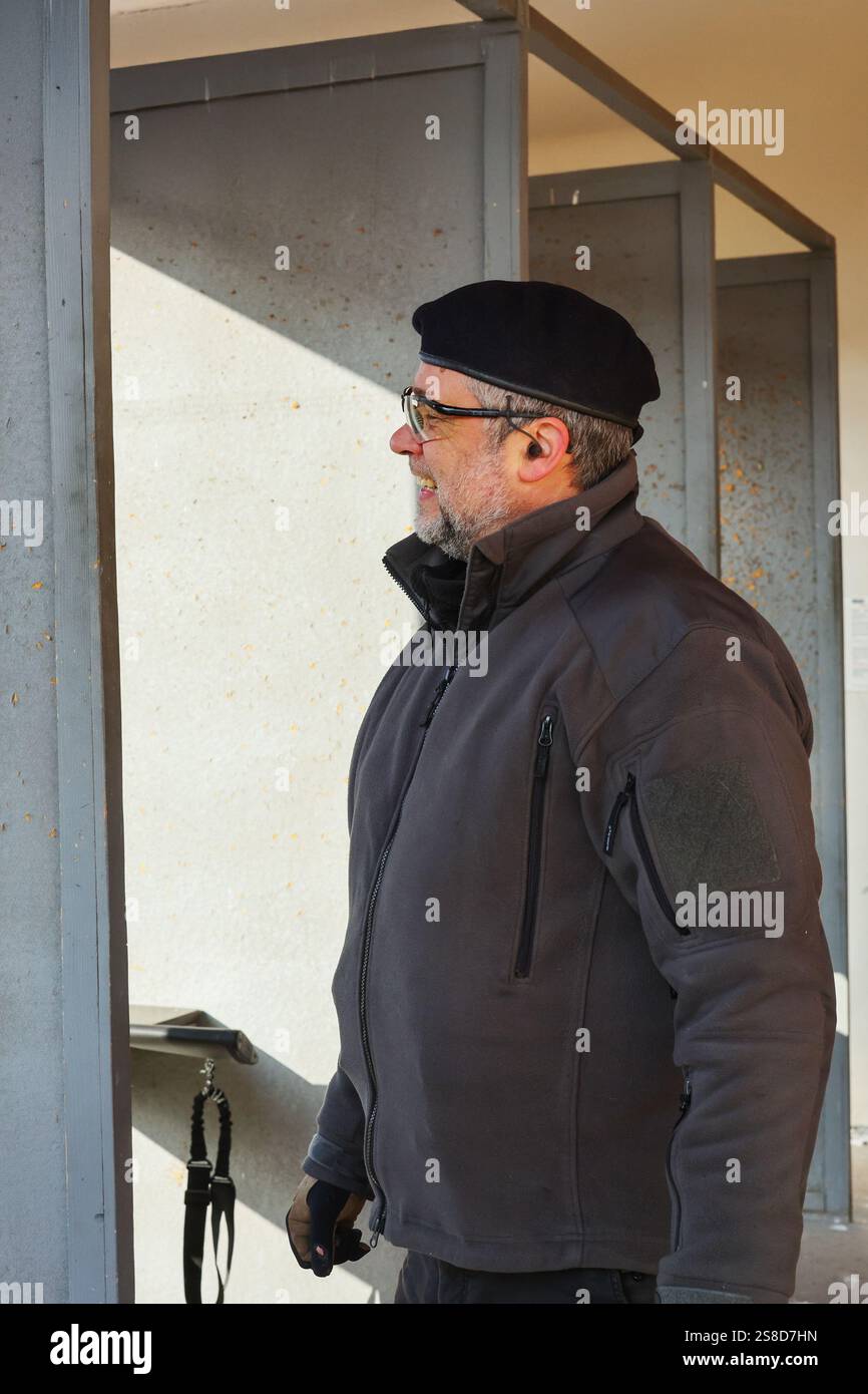 An instructor of shooting in a beret at a shooting range Stock Photo ...
