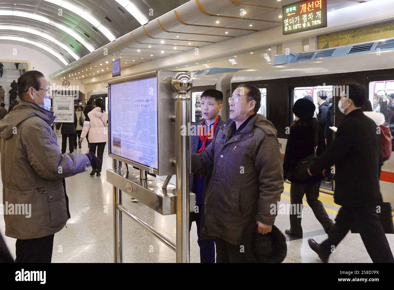 People read a copy of North Korea's official newspaper, Rodong Sinmun ...