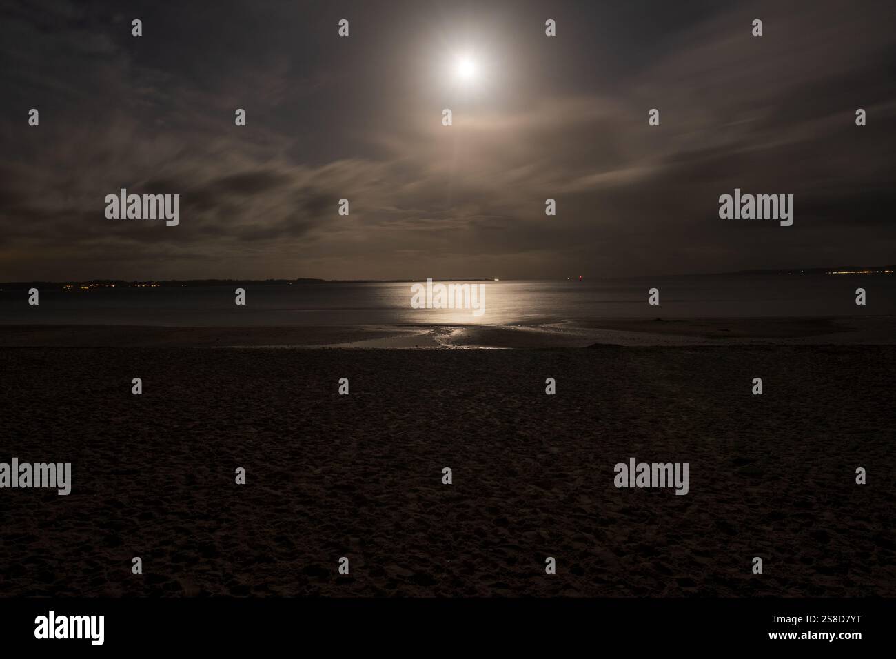 View of the full moon with clouds, the light is reflected in the Baltic ...