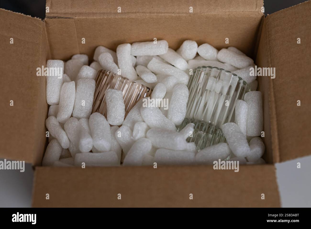 Eco-friendly cardboard box filled with white biodegradable packing ...