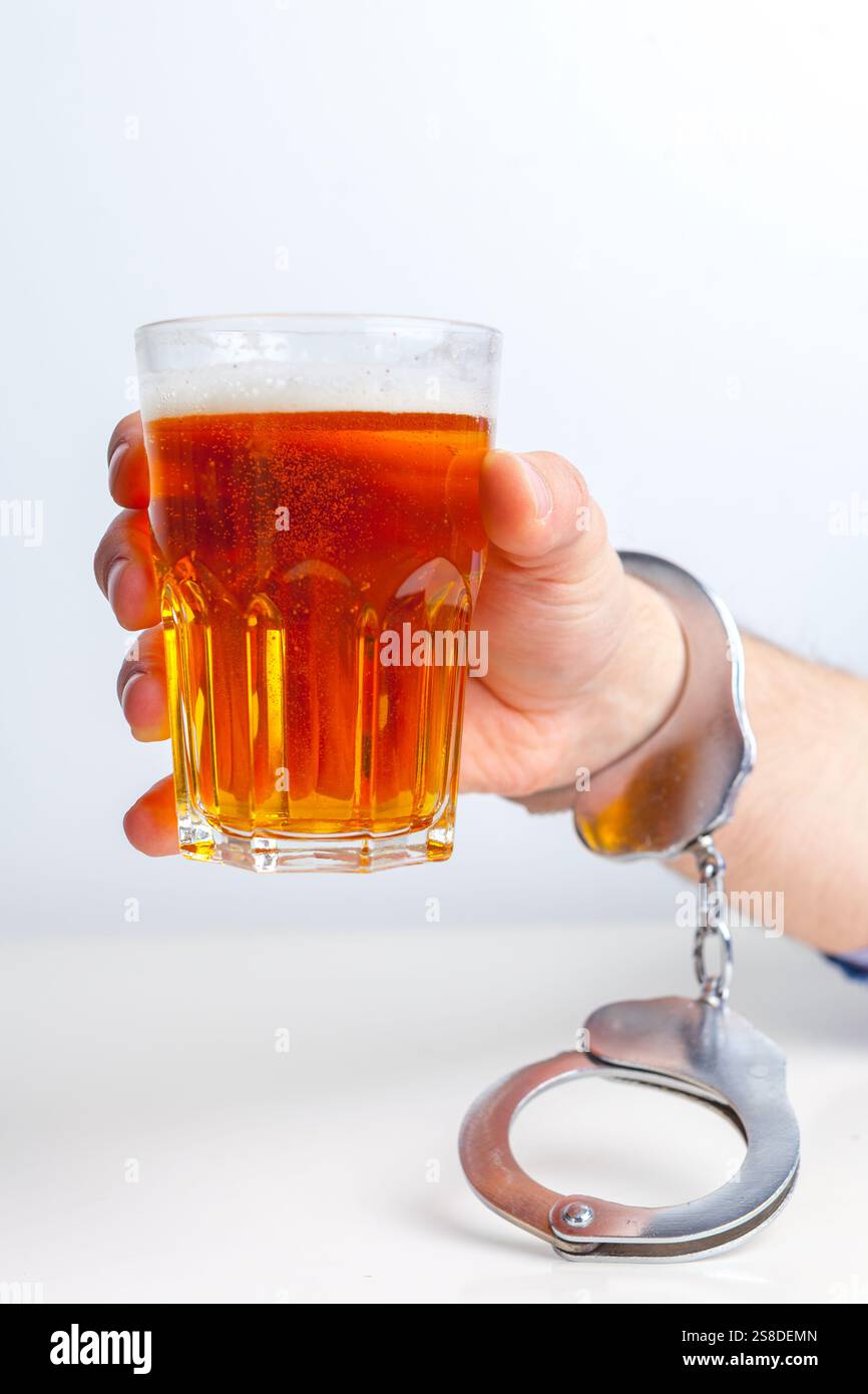 Glass of beer with handcuffs as symbol for alcohol abuse Stock Photo ...