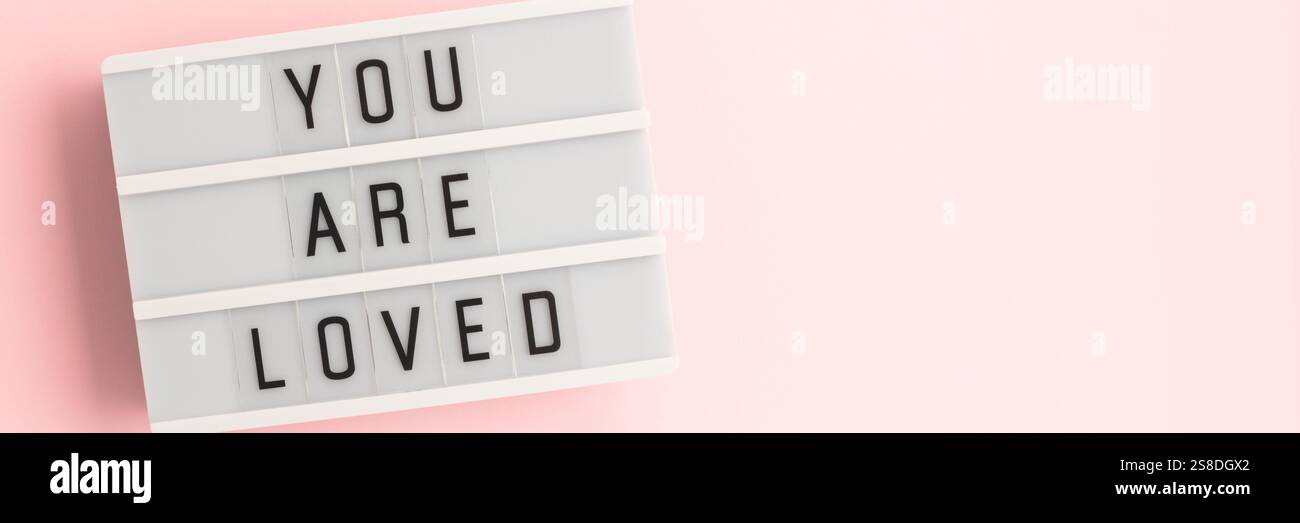 You are loved. Lightbox with letters on a pink background. Banner with ...