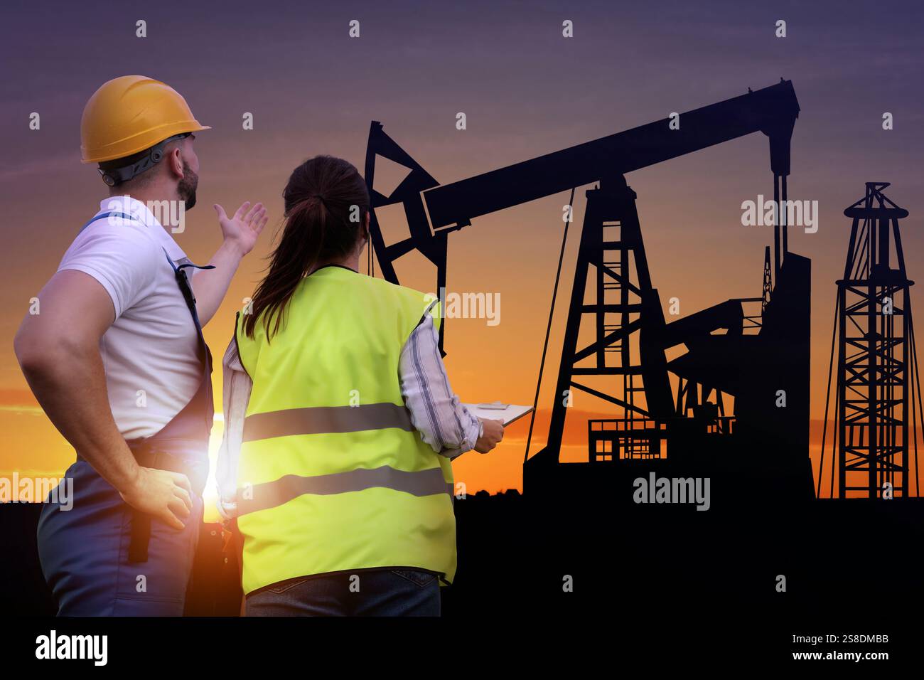 Workers at oil production site with crude oil pump Stock Photo - Alamy