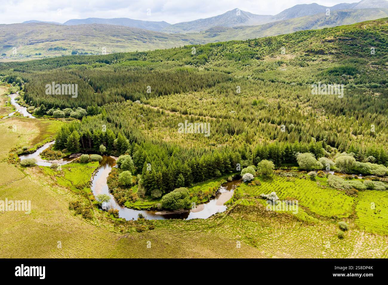 Aerial view of Joyce's river winding down below in Connemara region in ...