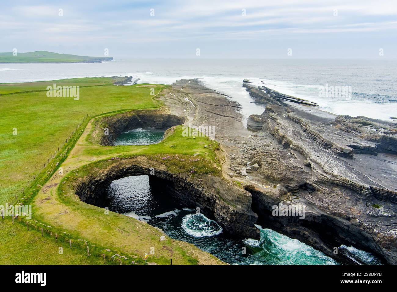 Aerial view of Bridges of Ross, three natural rock arches, carved into ...