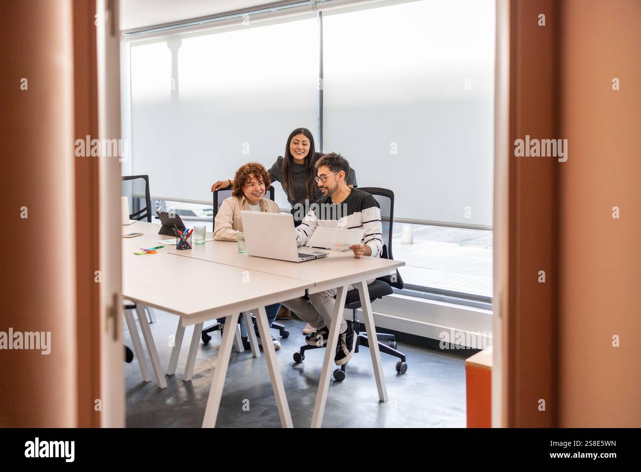 Three coworkers engage in a collaborative teamwork session, discussing ...