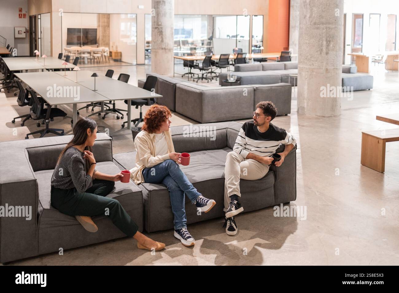 Three coworkers engage in a friendly and productive discussion in a ...