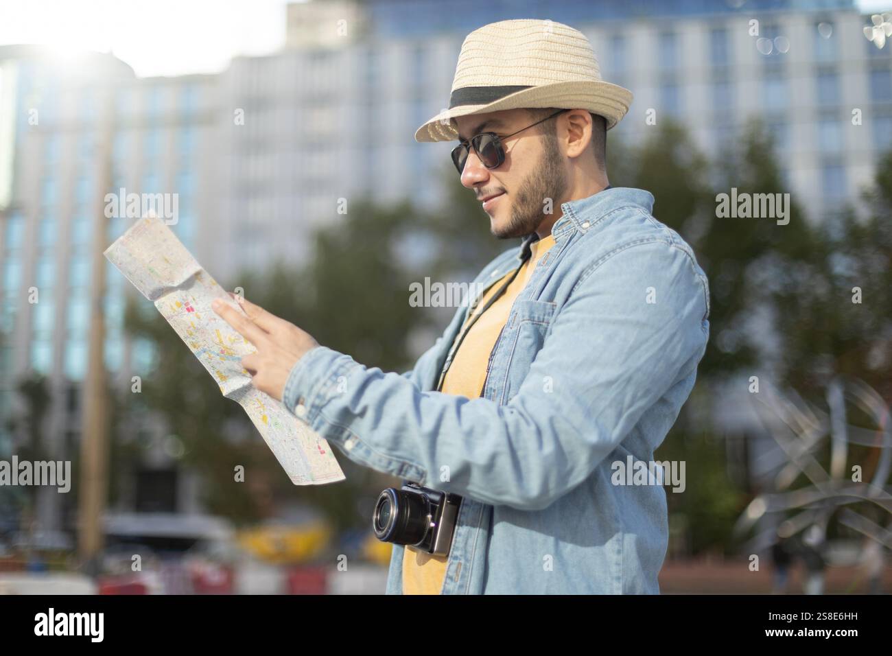 A Latino transgender man in a hat and sunglasses explores a city with a ...
