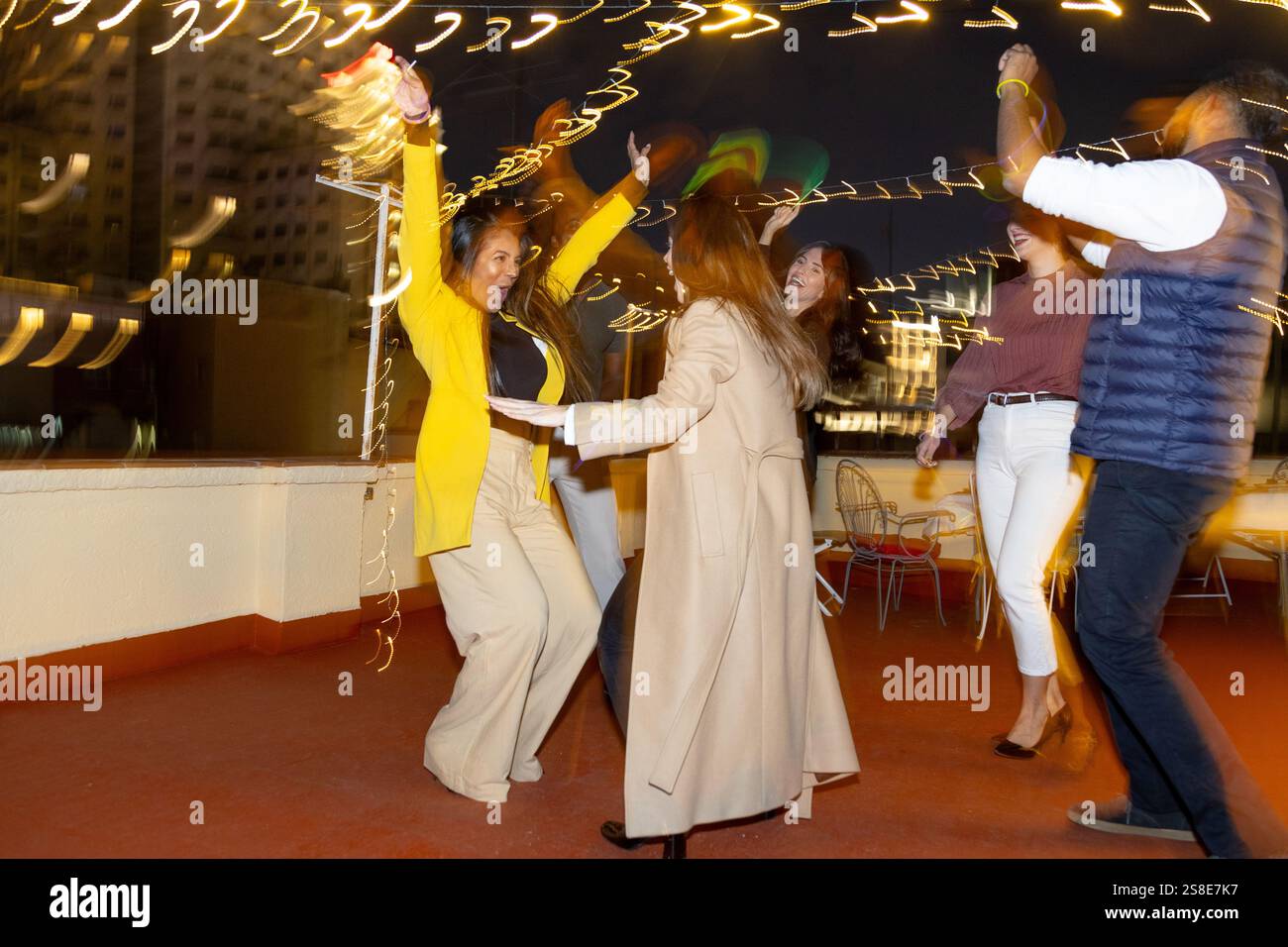 A joyful group of friends celebrates a vibrant rooftop party with fun ...