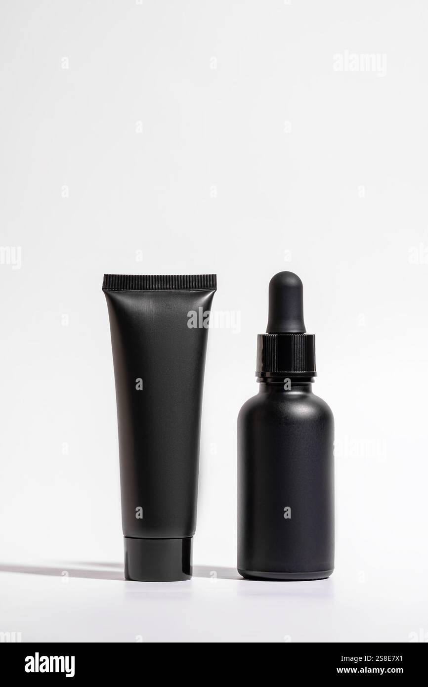 Elegant black cosmetic packaging featuring a tube and dropper bottle ...