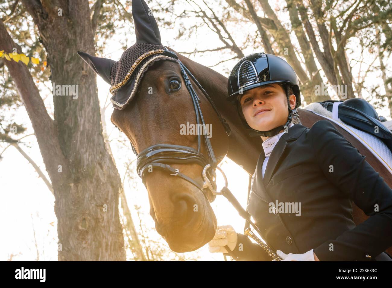 From below teenage girl, dressed in classical dressage attire ...