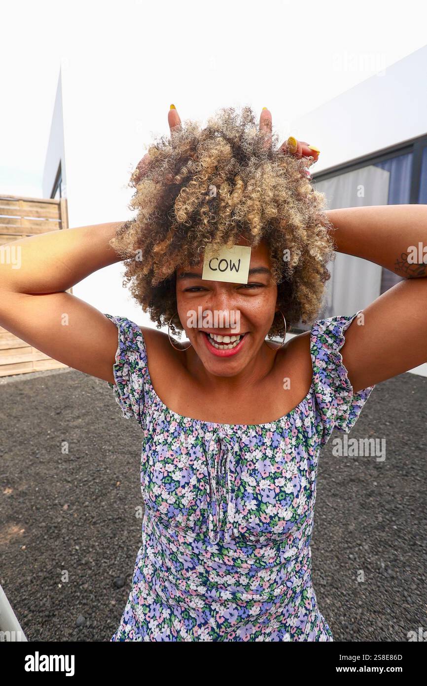A joyful african american woman with a sticky note on her forehead ...