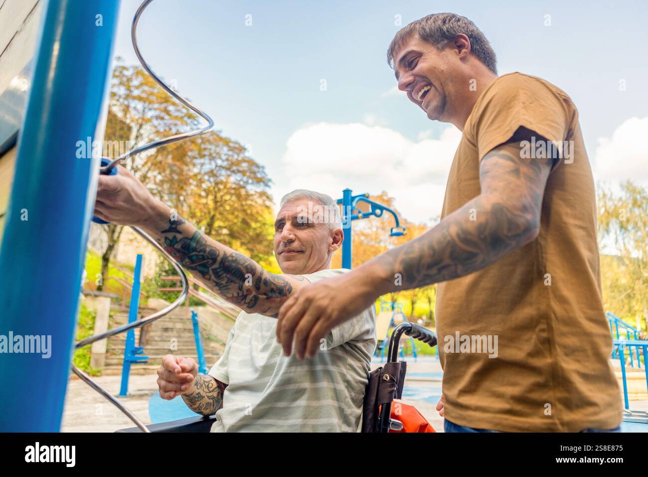 Two friends, one in a wheelchair by cerebral palsy, enjoy a sunny day ...