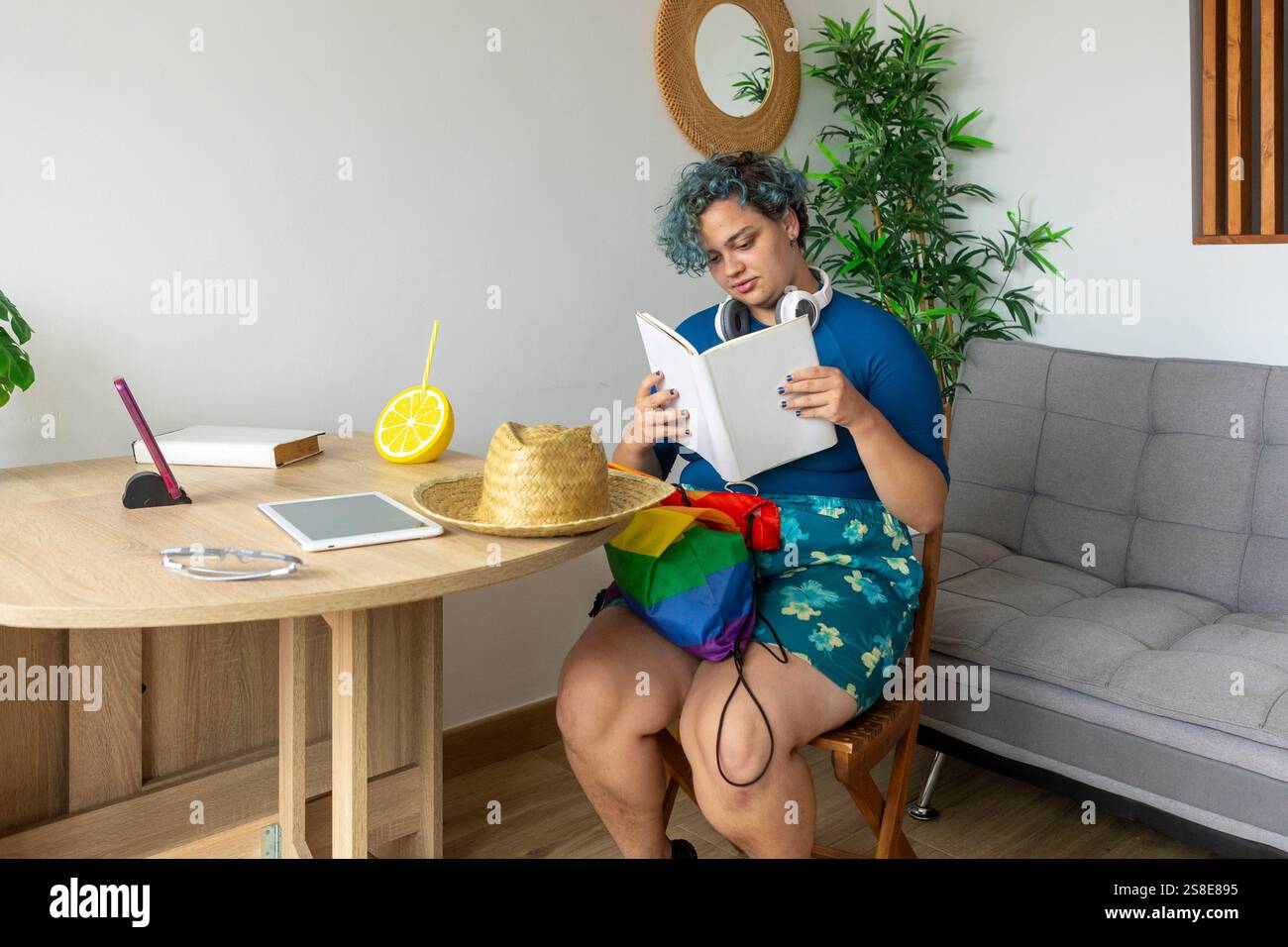 A transgender man, sitting comfortably in a modern styled room. He is ...