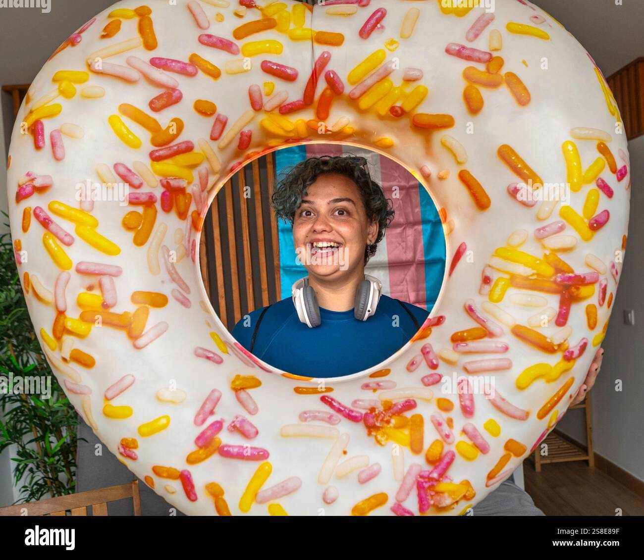 A joyful transgender person with a playful expression peeks through a ...