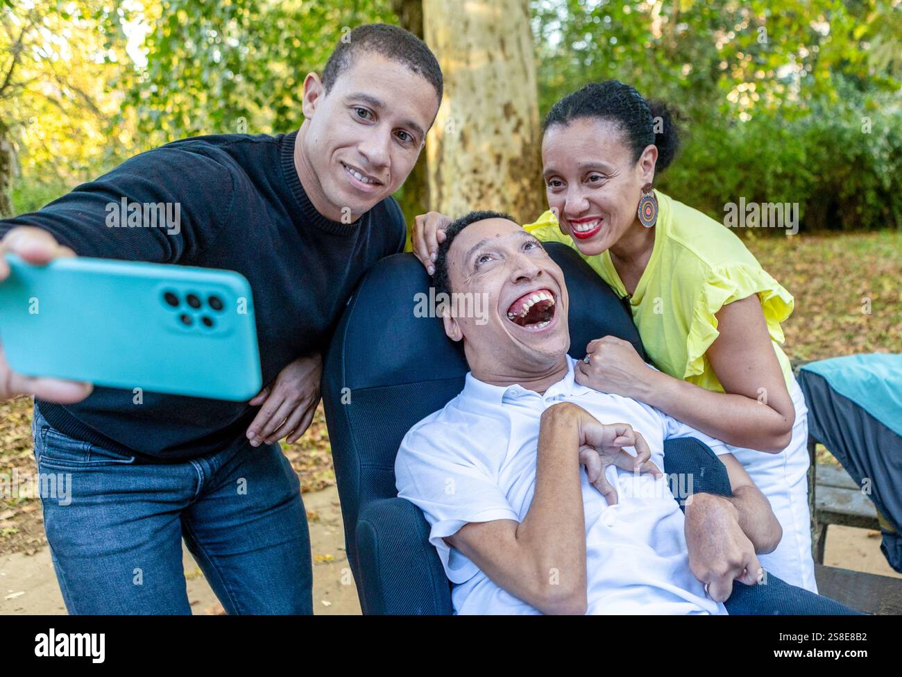 Two siblings pose for a joyful selfie with their disabled brother, who ...