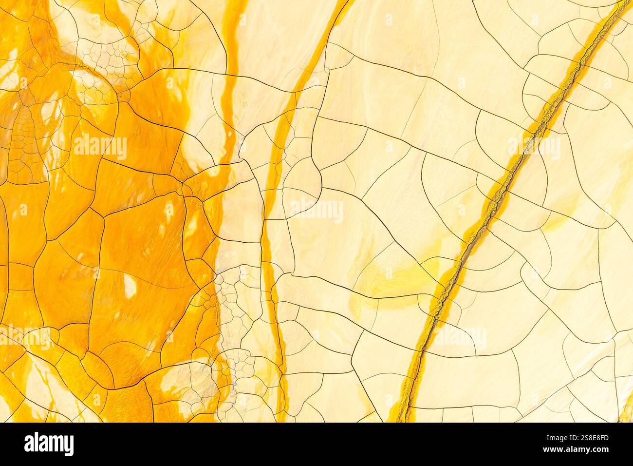 An evocative shot of a textured surface resembling golden mud ...