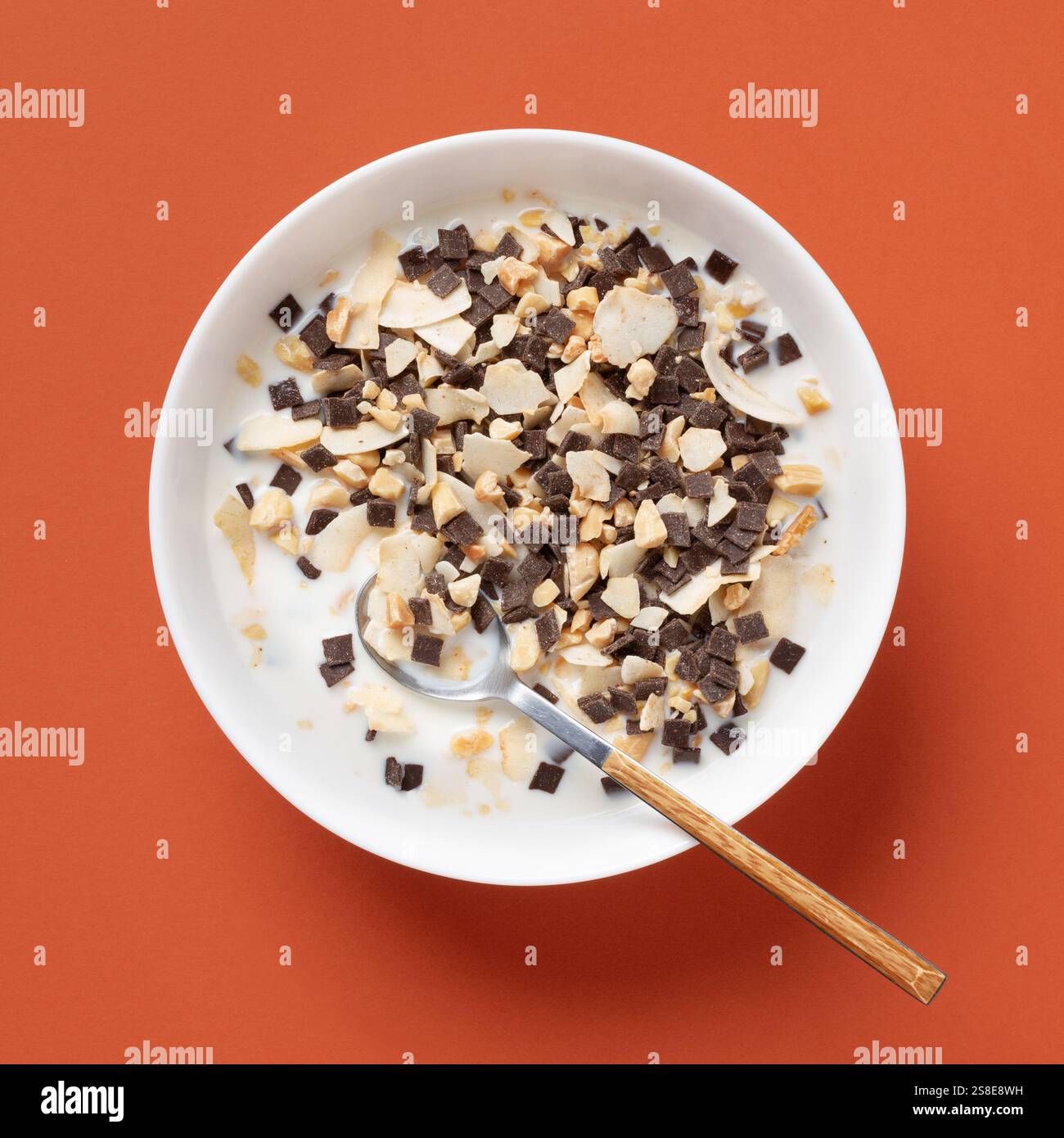 Top view of a white bowl filled with cereal, sliced almonds, and chunks ...