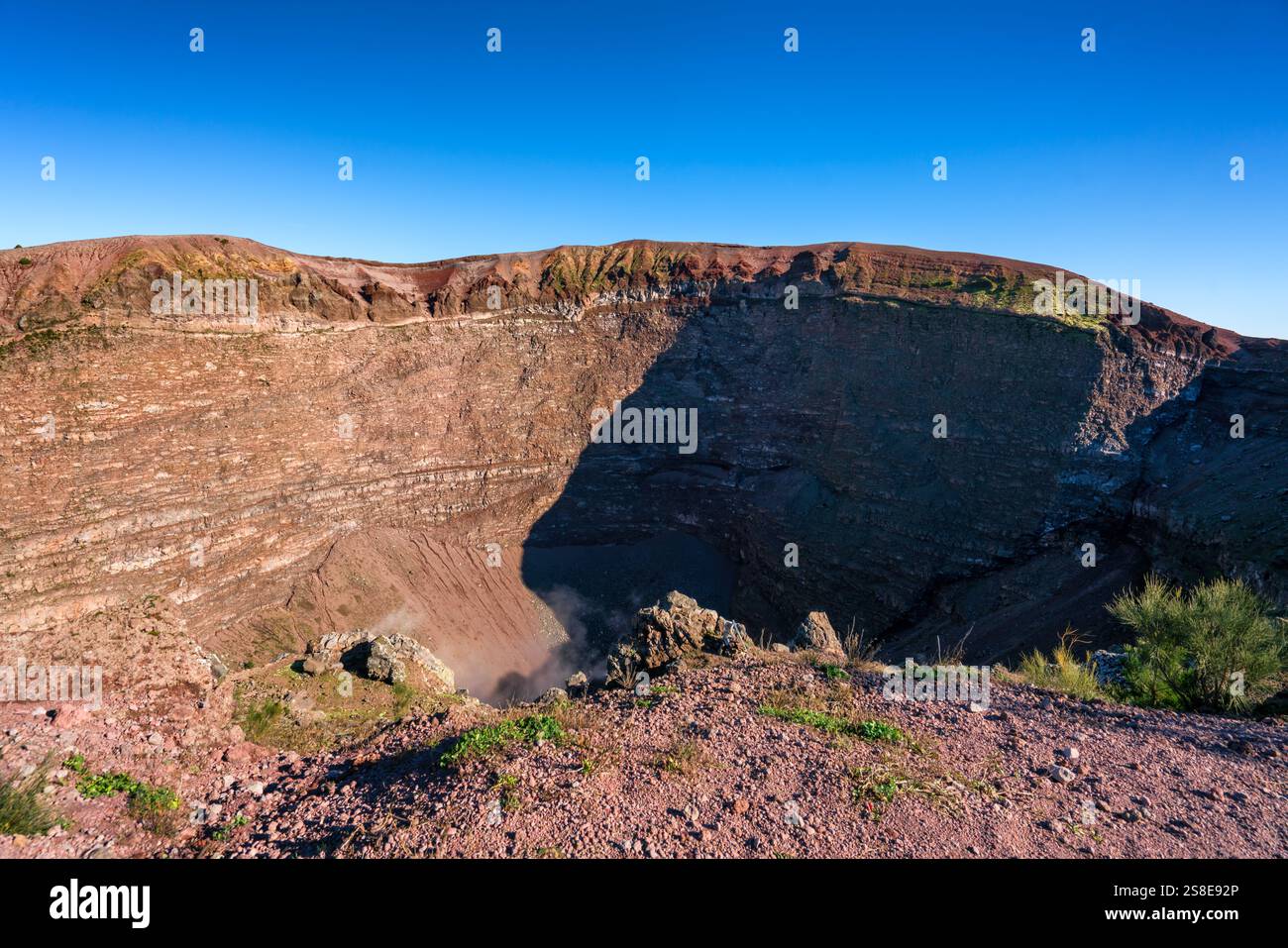 The vast crater of Mount Vesuvius, surrounded by steep red rock walls ...