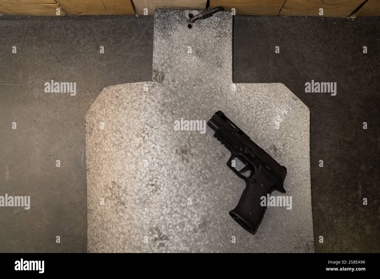A steel target and a tactical pistol on the floor at a shooting range ...