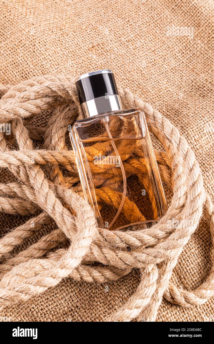 A sophisticated male perfume bottle nestled in a rustic rope set ...