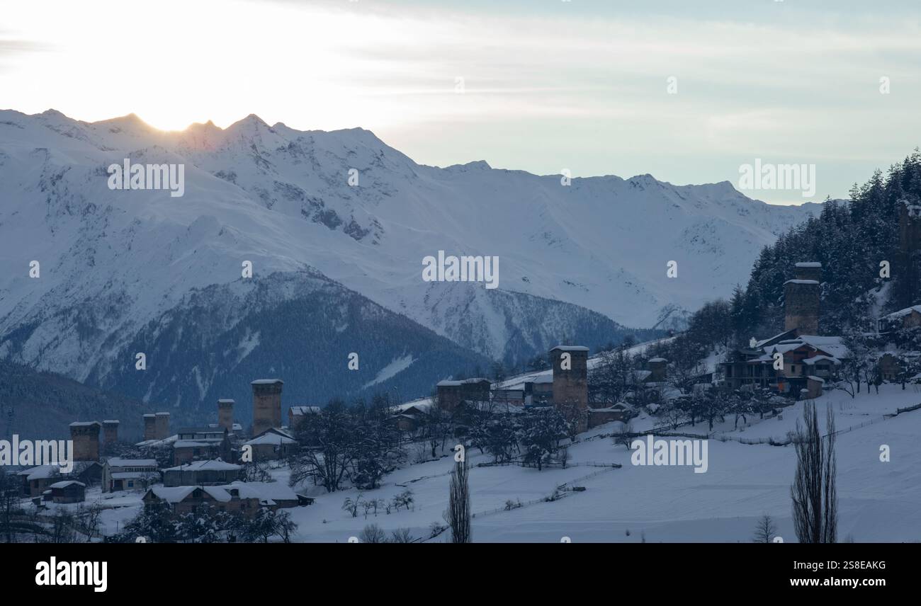 A serene winter morning with the sun rising over snow-capped mountains ...